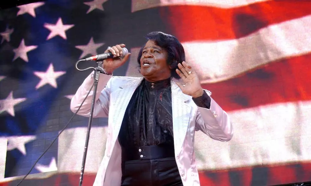 James Brown, canwr y gân wladgarol ac anthem 4ydd o Orffennaf Byw yn America, yn canu o flaen baner America