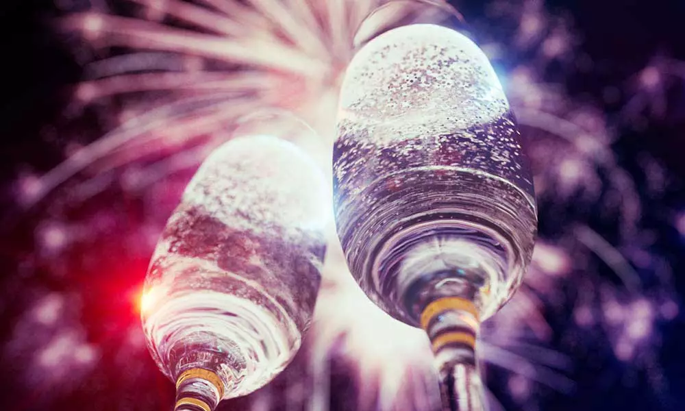 Mejor música clásica para Año Nuevo: imagen destacada de copas de champán y fuegos artificiales
